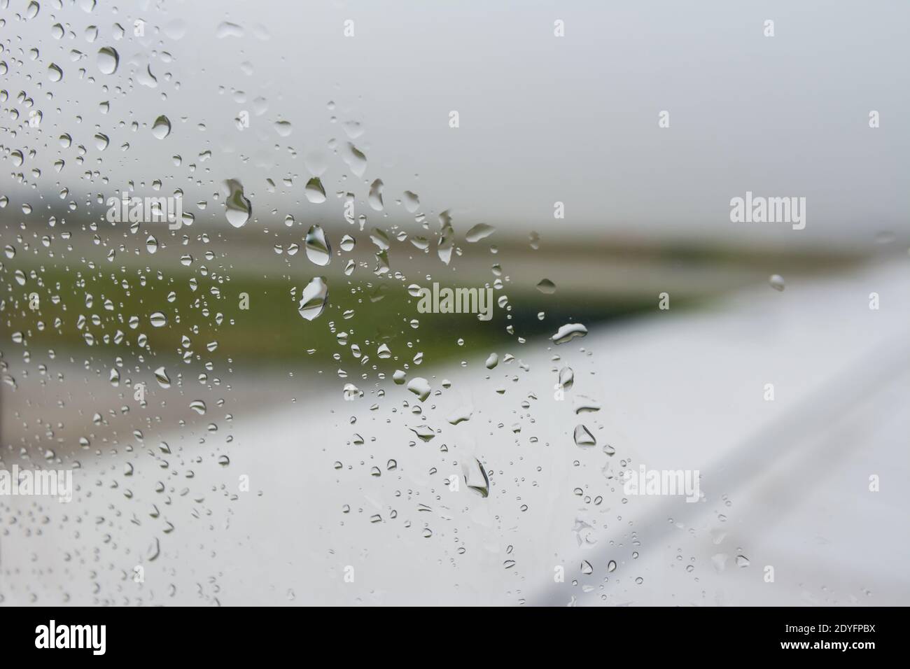 Water drop on the transparent glass window of airplane with blurred ...