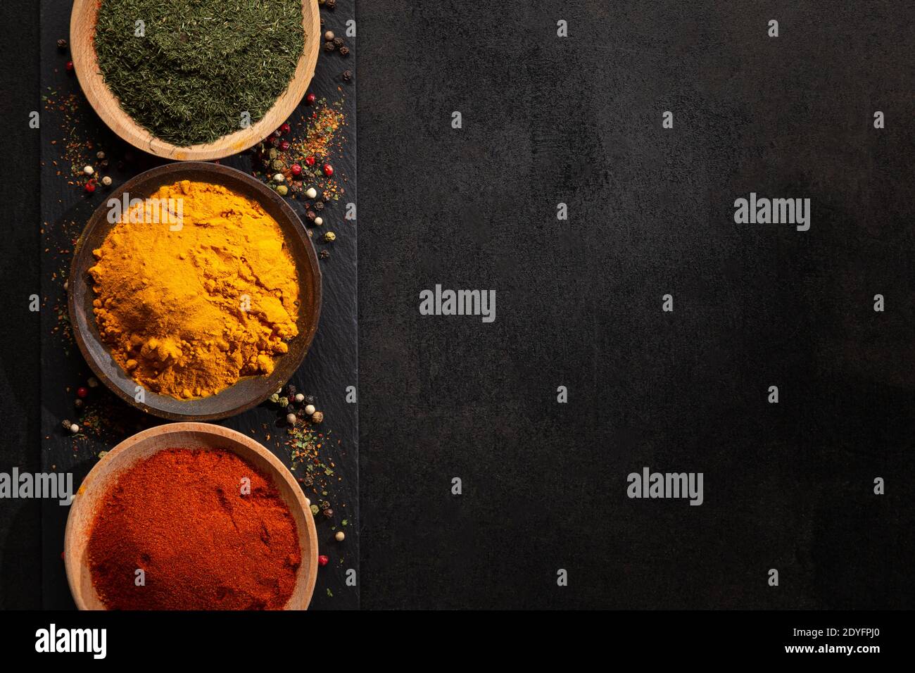 Various spices on a black background, top view, with copy space ...