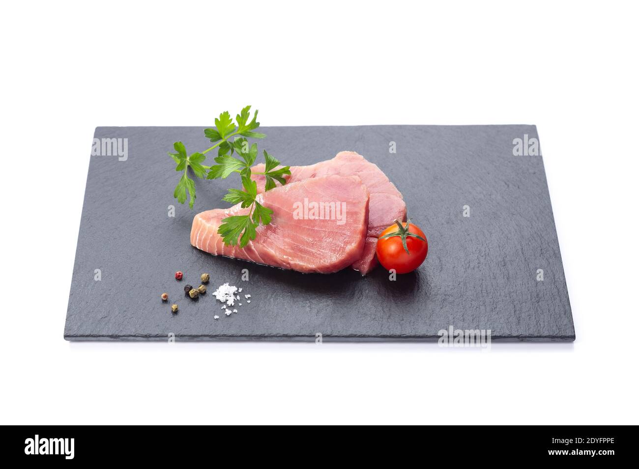 Fresh raw tuna fillets with seasoning, in a slate plate on white ...