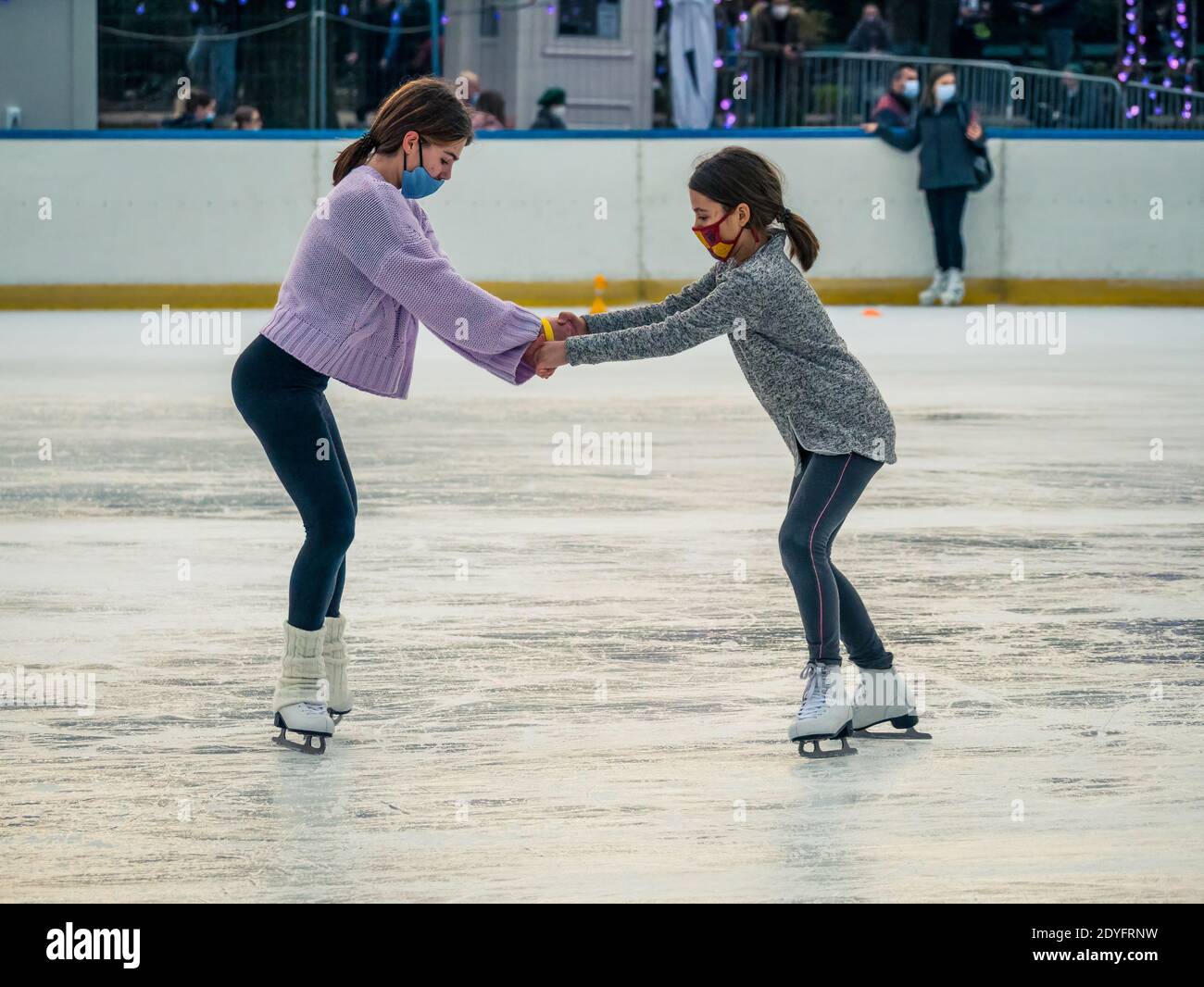 Bucharest Romania - 12.25.2020: Two young girls ice skating on the ice ...
