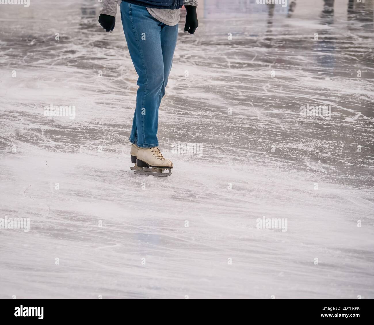 Legs of a woman with skates on ice. Ice skating recreational activity ...
