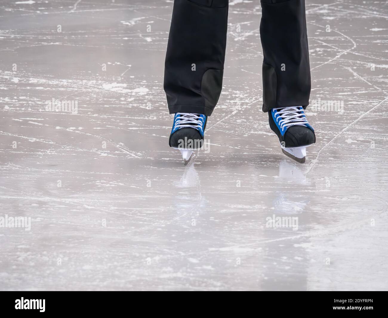 Legs of a woman or man with skates on ice. Ice skating recreational ...