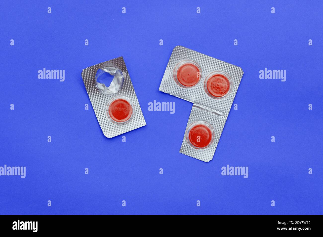 Red pills in packaging on a colored background. Pain medicine ...
