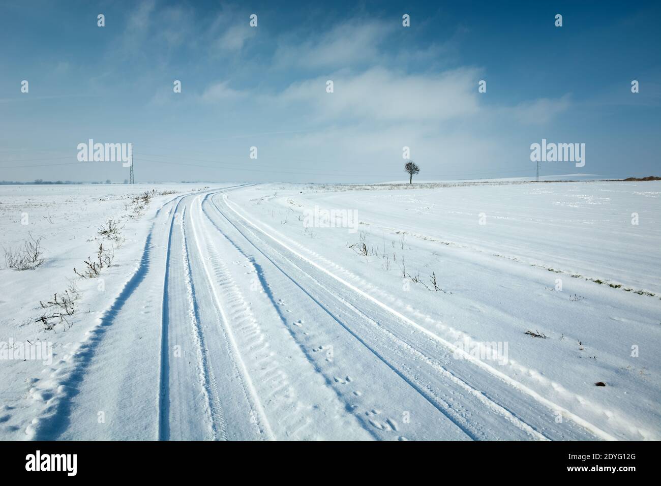 Snow road through fields and blue sky Stock Photo - Alamy