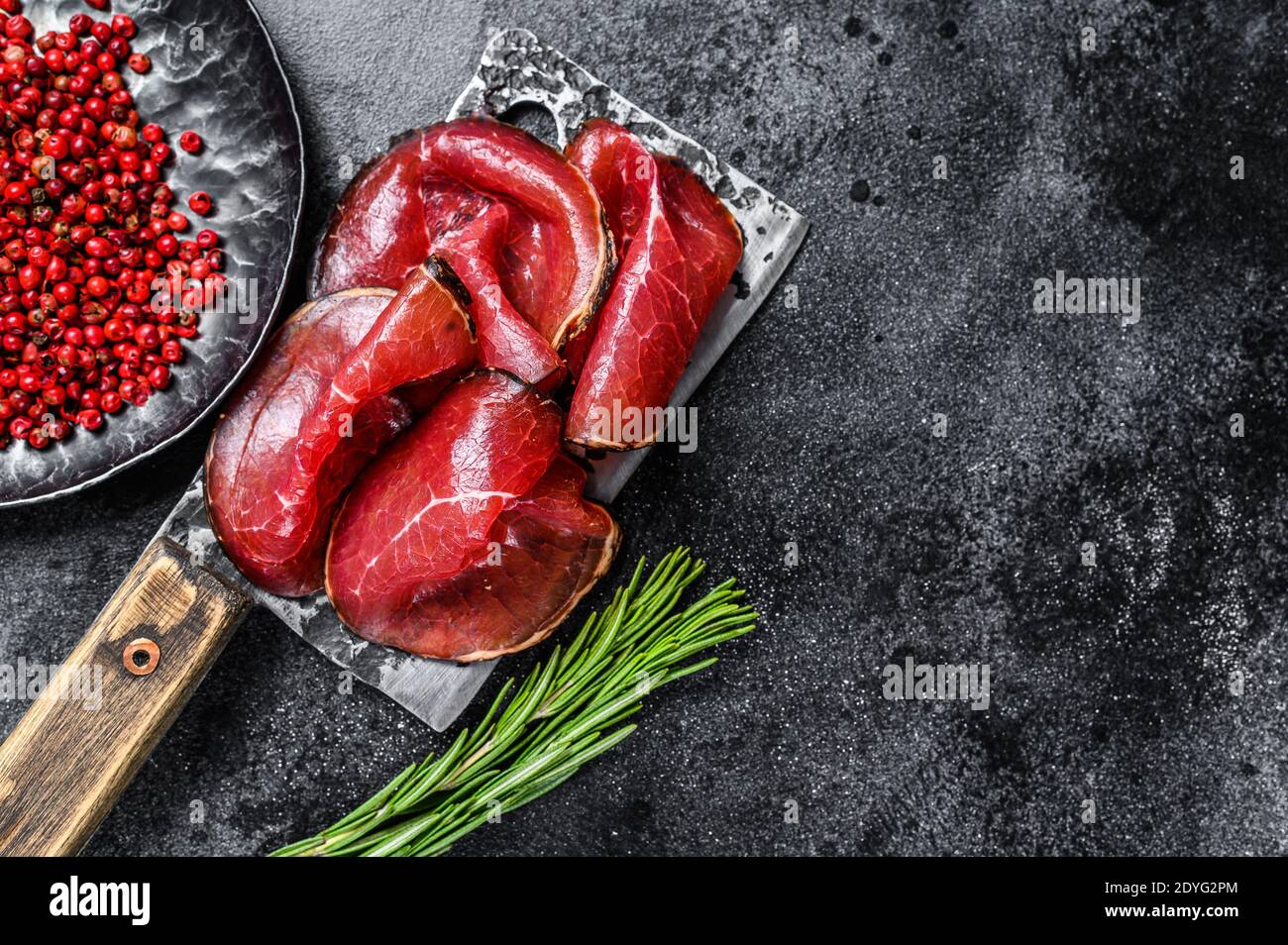 Bresaola dried beef meat sliced on a cleaver. Black background. Top ...