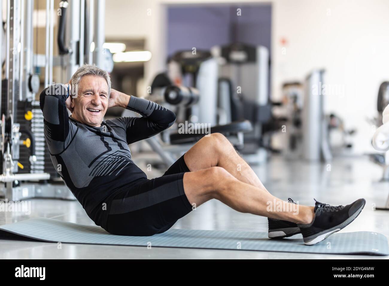 Pensioner male staying fit by making situps inside a gym Stock Photo ...