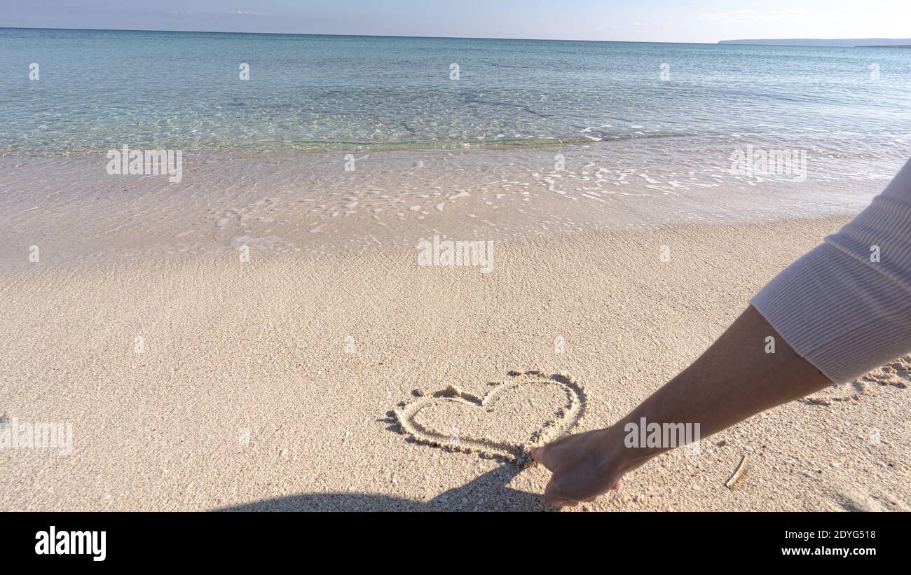 hand drawing heart on the beach shore Stock Photo - Alamy