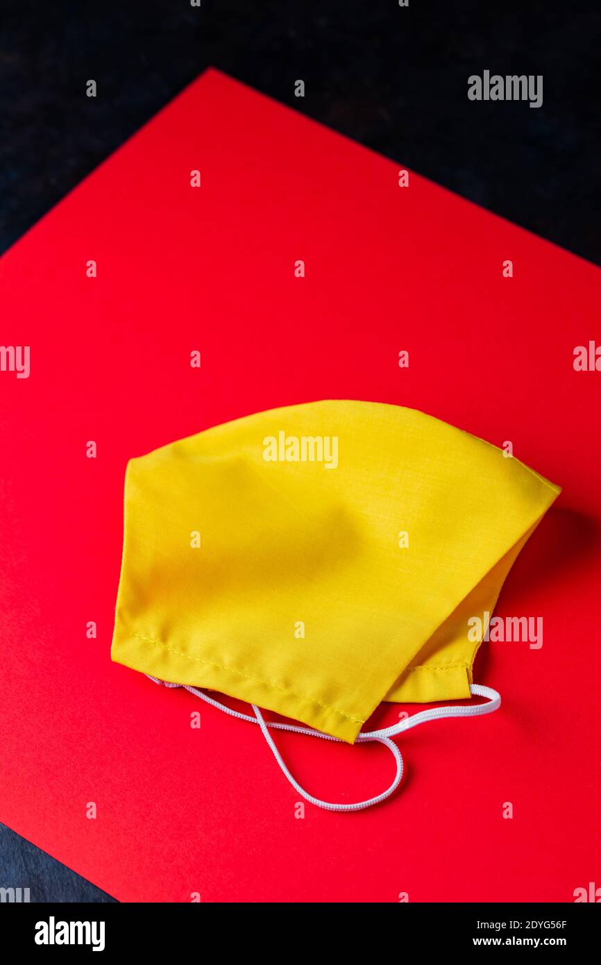 Face protective mask on a dark background. Yellow face mask on red ...