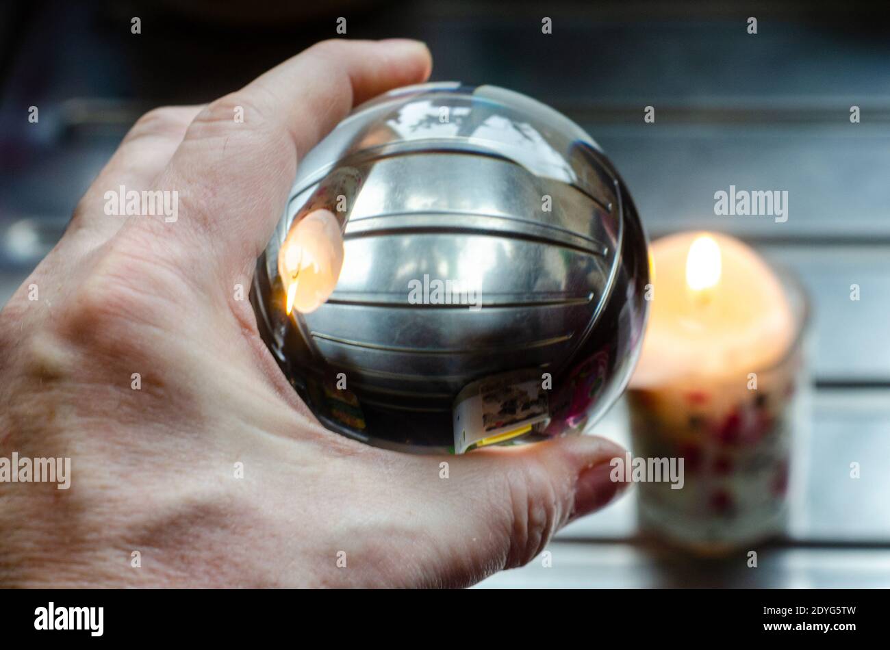 A candle on a draining board is seen upside down in a glass crystal ...