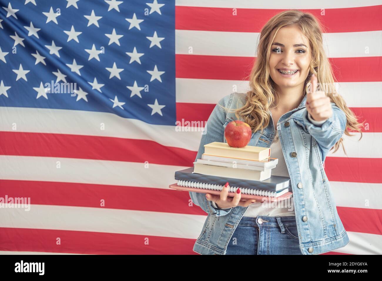 Happy college or university student holding study materials and an ...