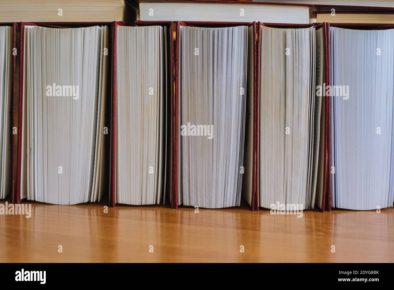 A row of half-open books lying on the desk Stock Photo - Alamy