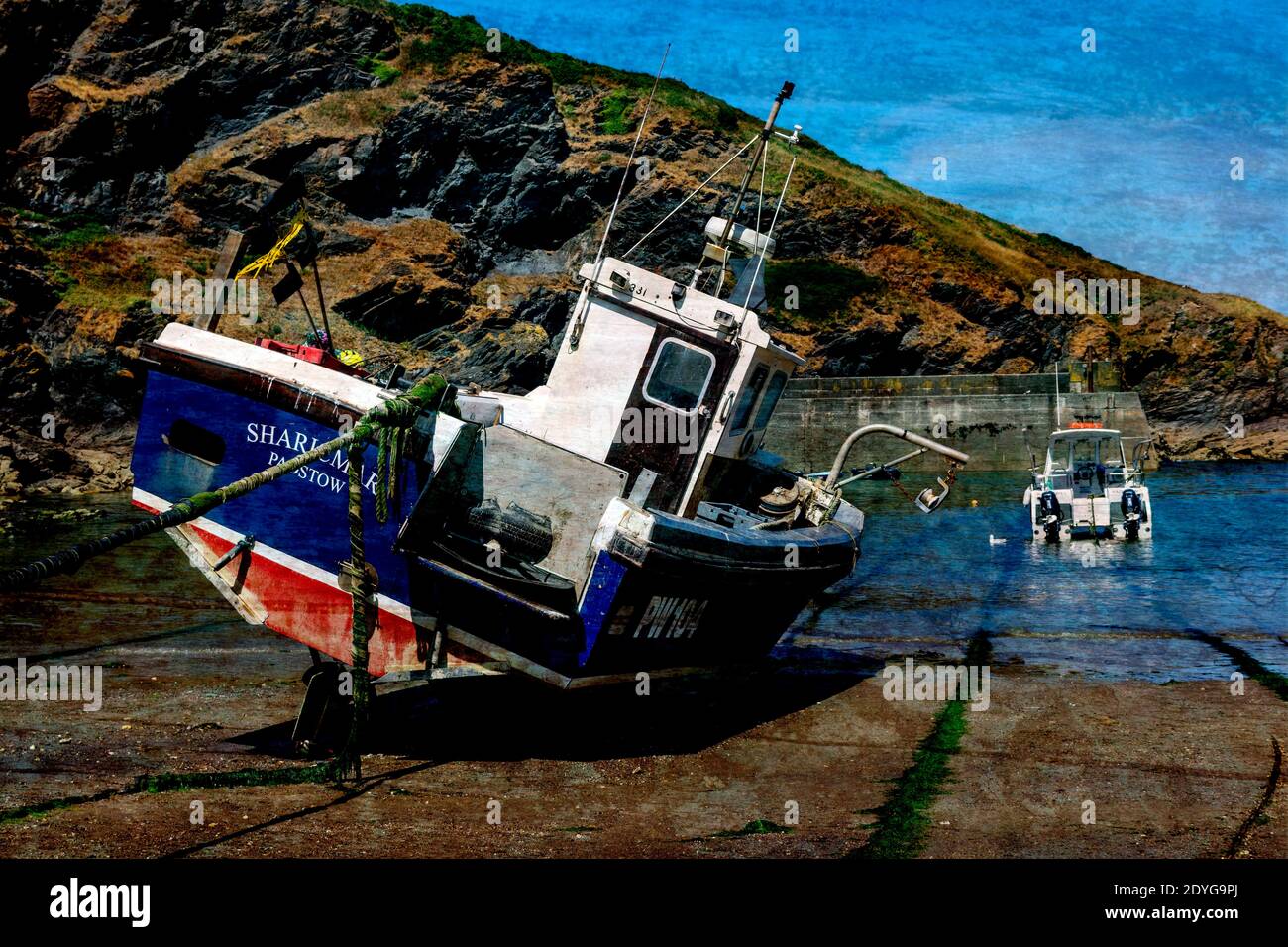 A fishing boat anchored in Port Isaac bay when the tide is out. The ...