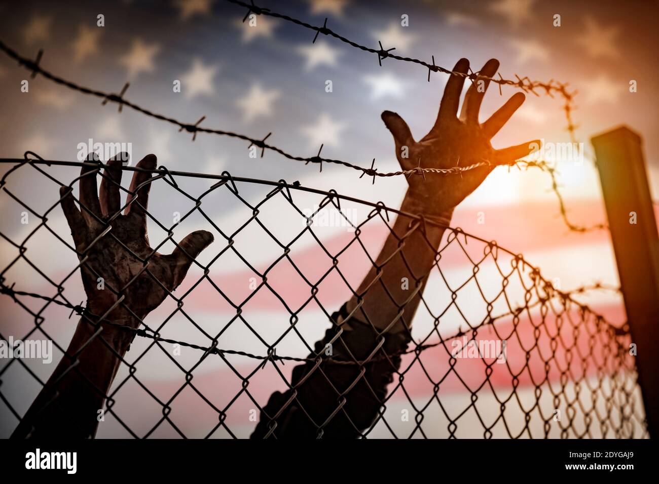Refugee men and fence ,United States of America flag in background ...