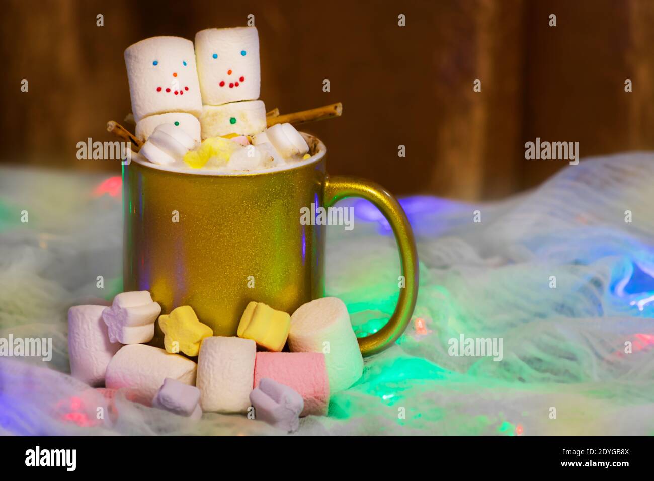 Yellow cup of hot beverage with melted funny marshmallow snowman ...