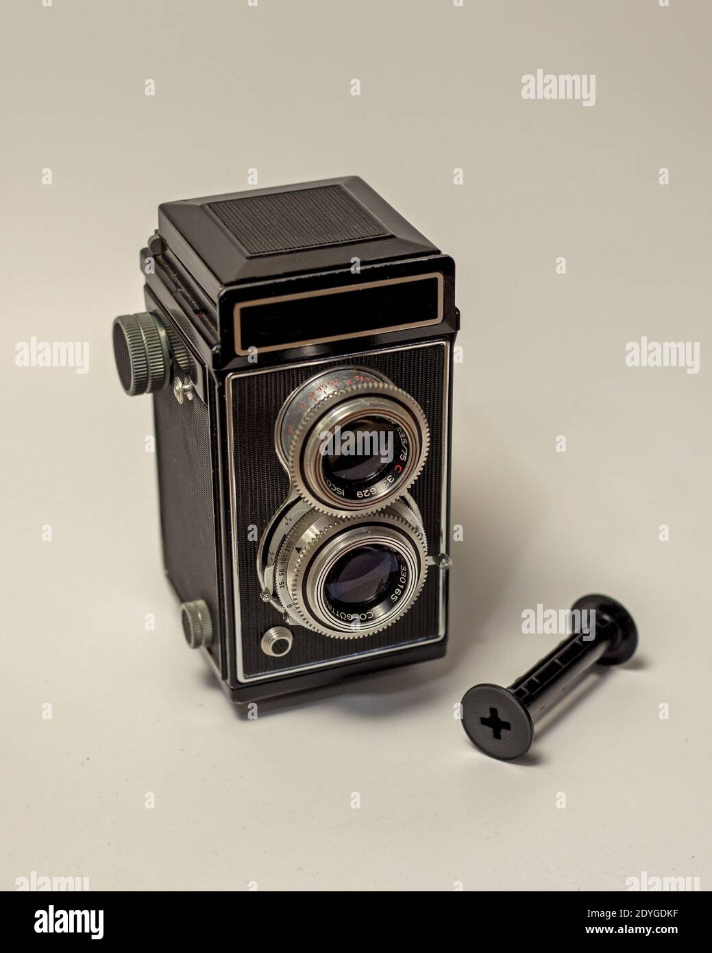 A vertical high angle shot of a vintage twin-lens camera on a white ...