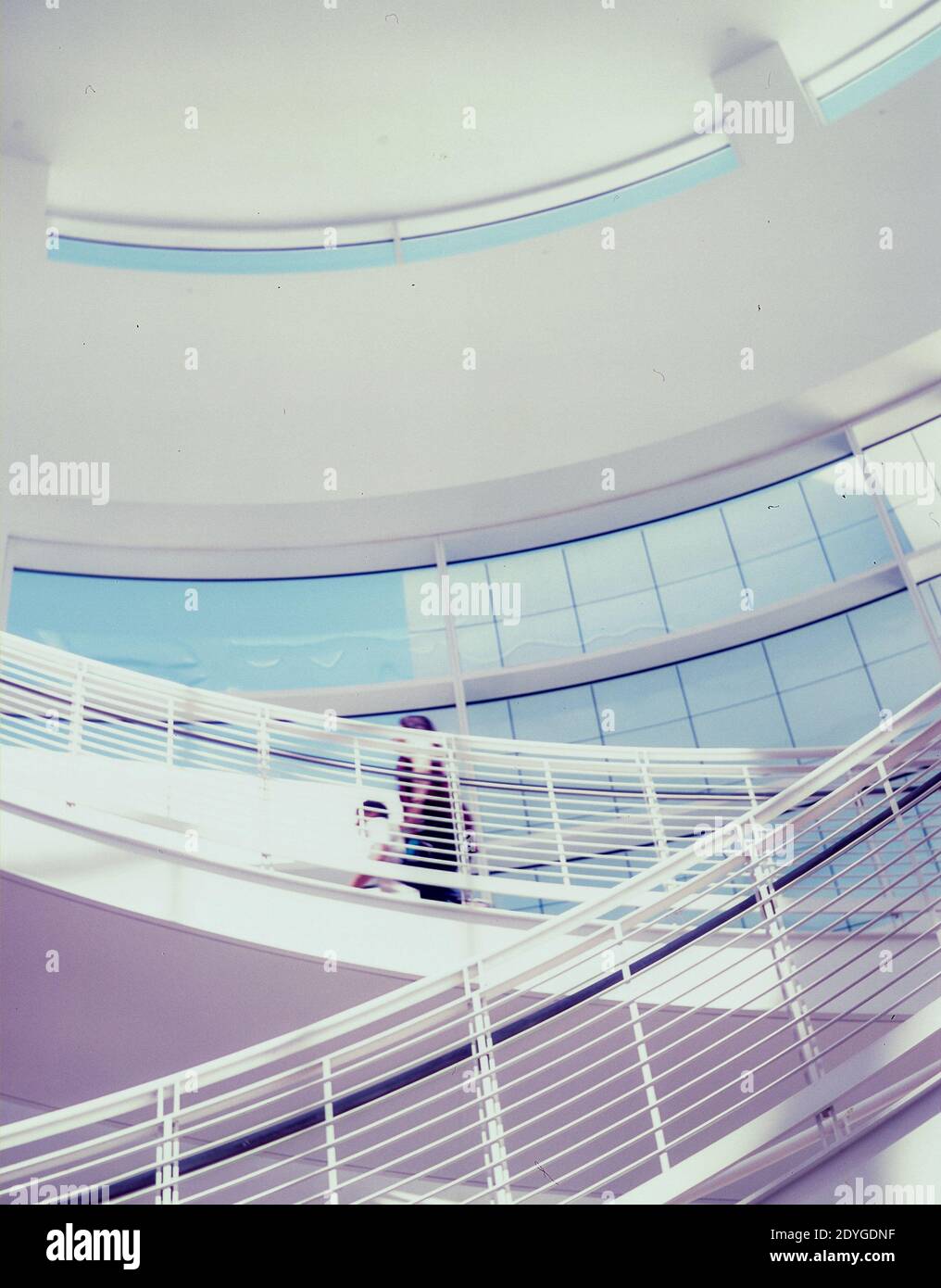 A vertical low angle shot of people climbing the stairs in a modern ...