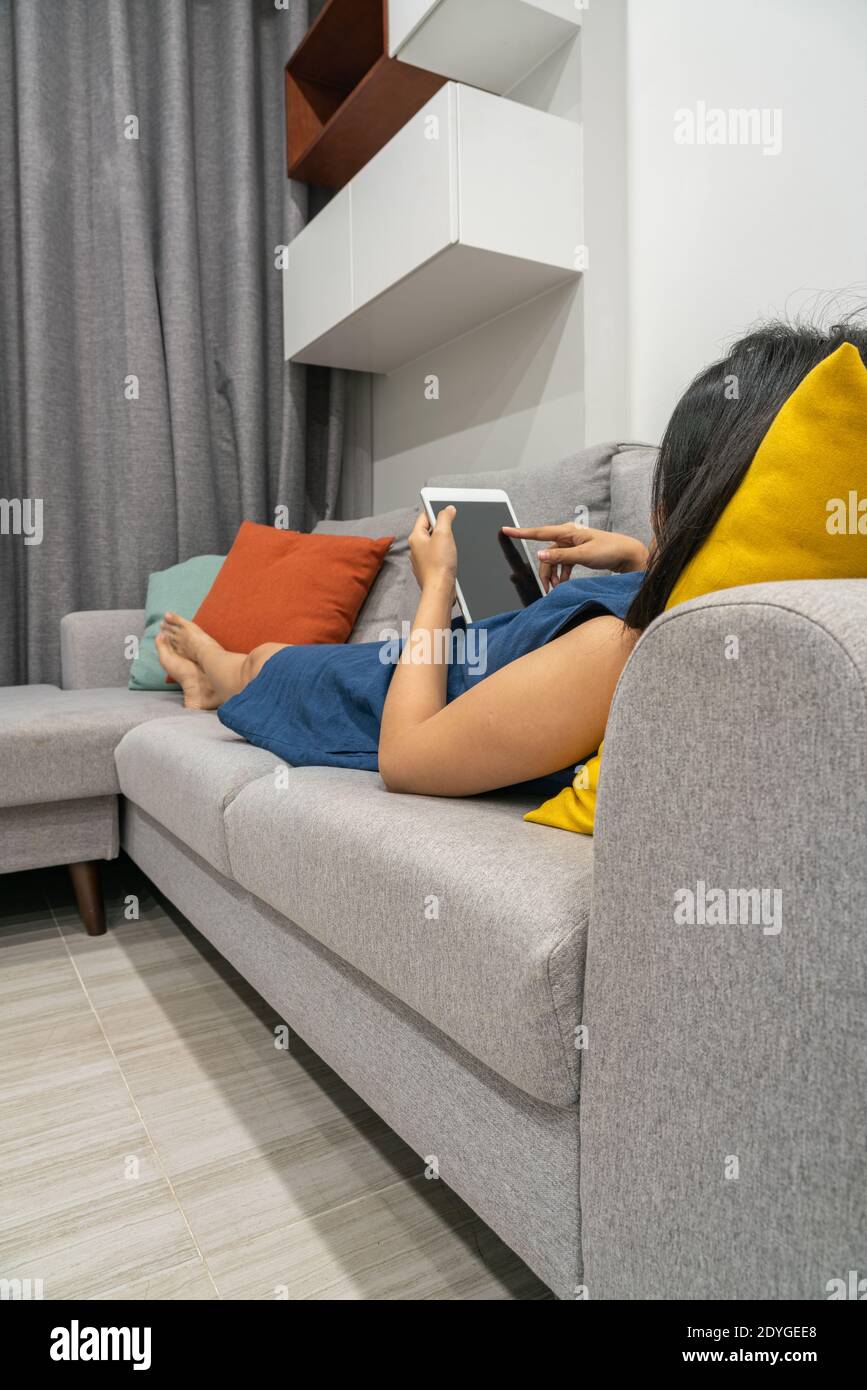 Vertical photo of young woman surfing the Internet on tablet Stock ...