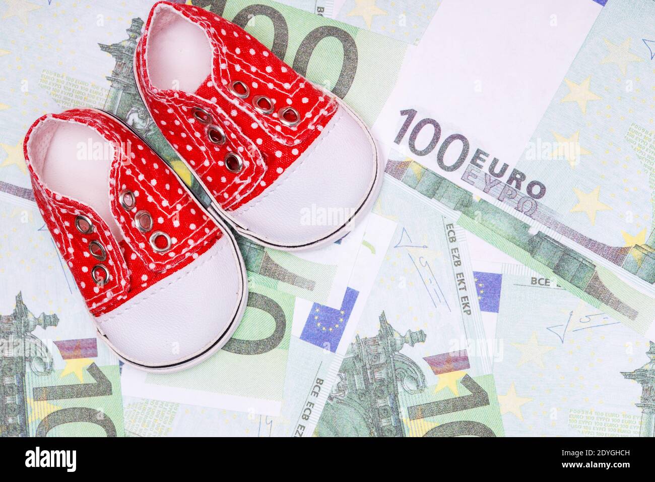 children's shoes with white polka dots on a background of money. 100 ...