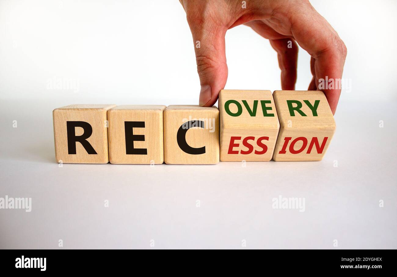 Recession or recovery symbol. Hand turns cubes and changes the word ...
