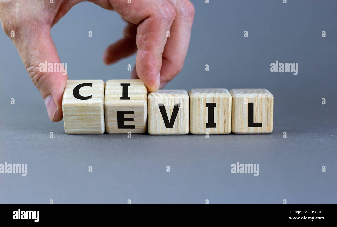 Civil or evil symbol. Male hand flips wooden cubes and changes the word ...