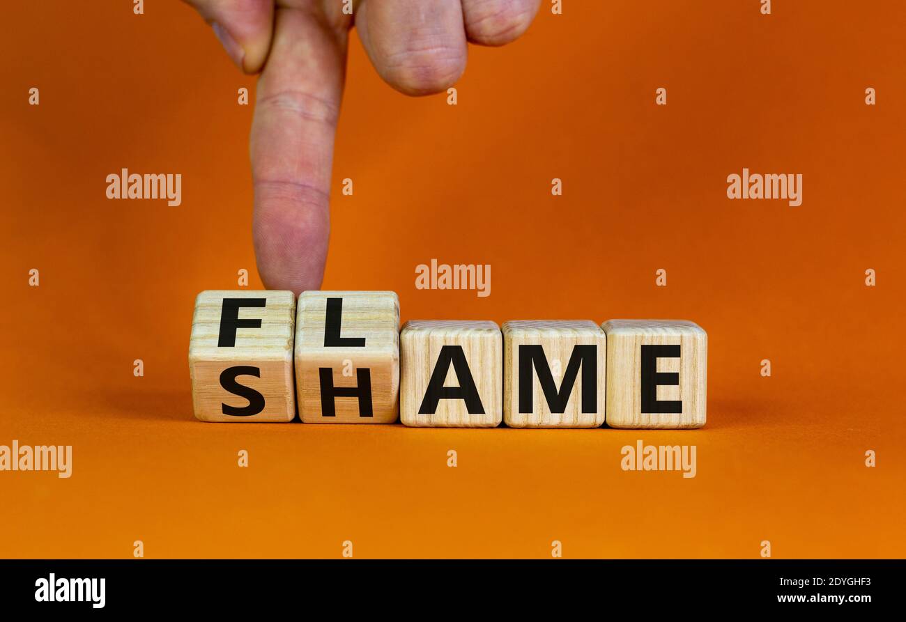 Flame of shame symbol. Male hand flips wooden cubes and changes the ...