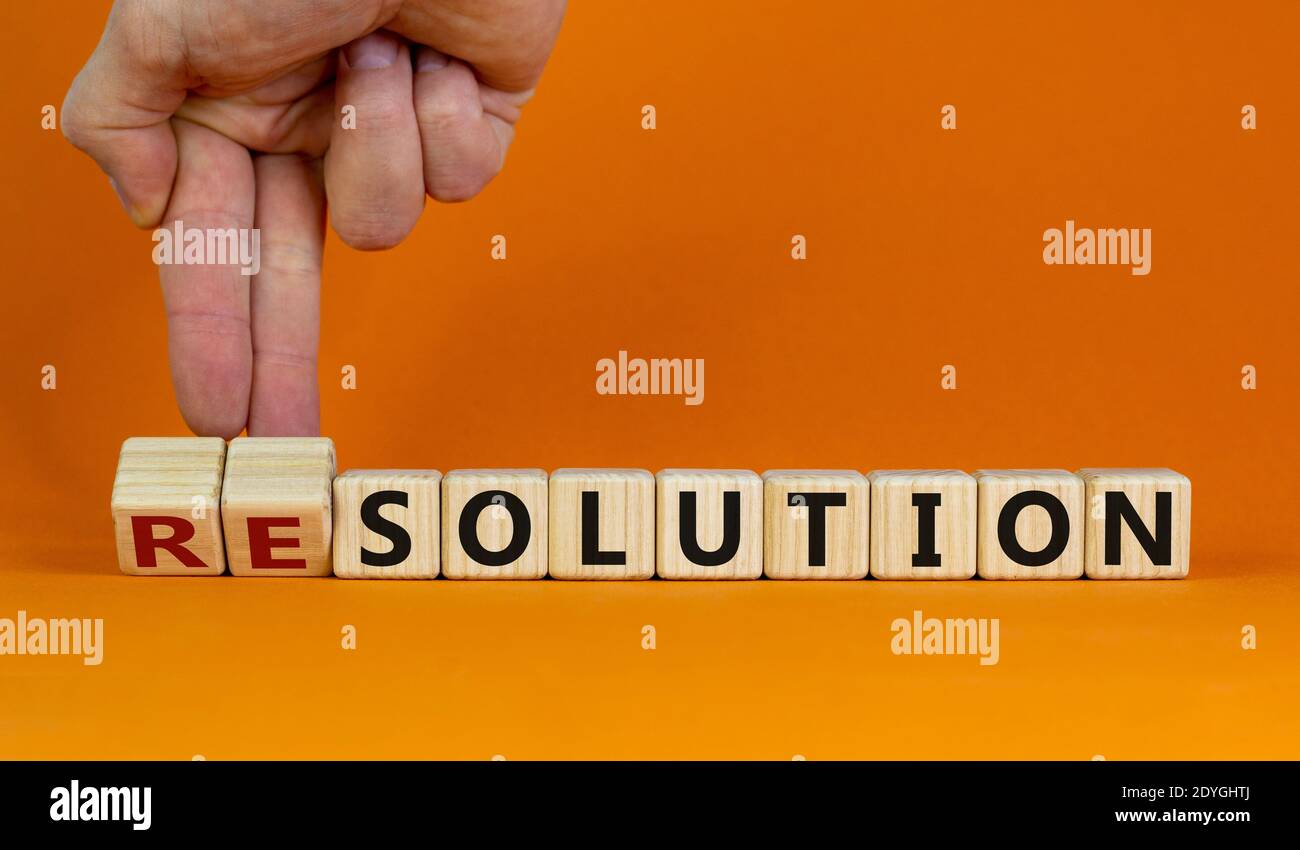 New years solution or resolution. Male hand flips wooden cubes and ...