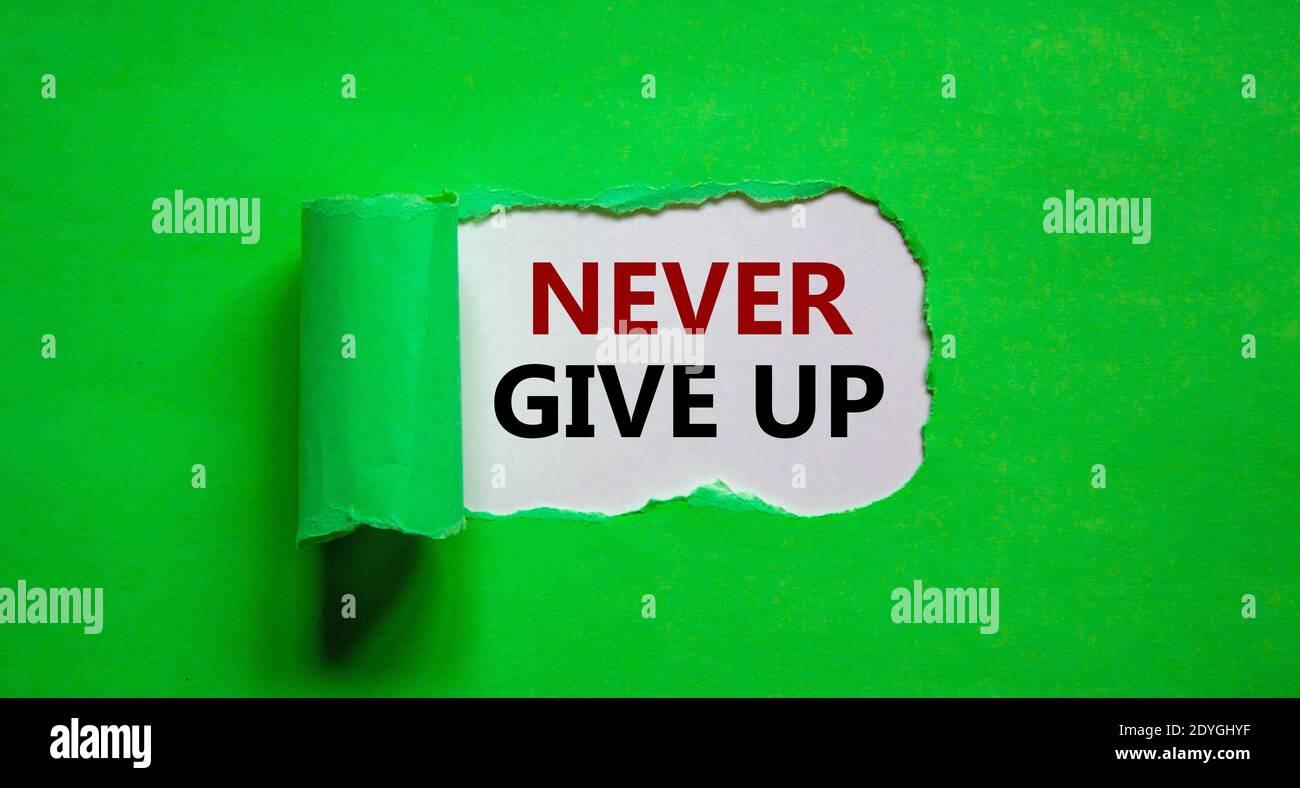 Never give up symbol. Words 'Never give up' appearing behind torn green ...