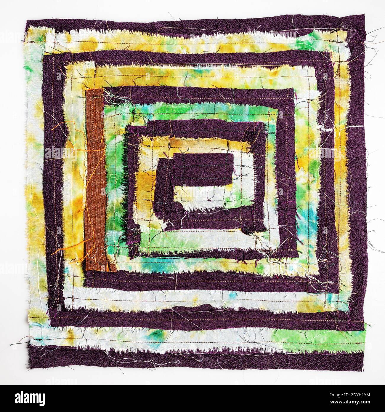 back side of stitched detail of patchwork fabric with yellow spiral ...