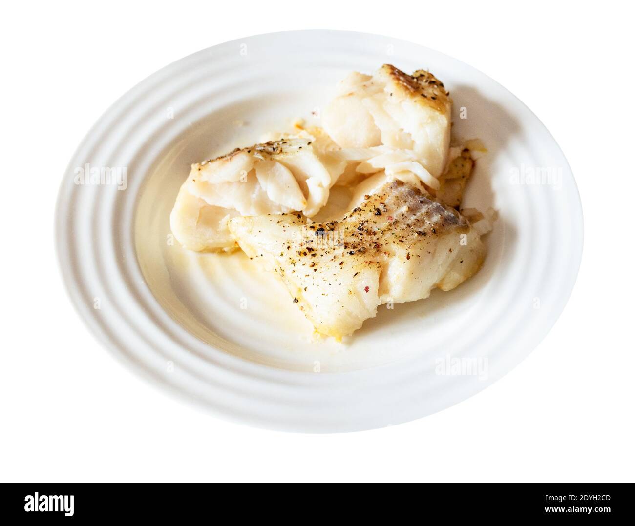 pieces of baked and peppered cod fish on white plate cut out on white ...