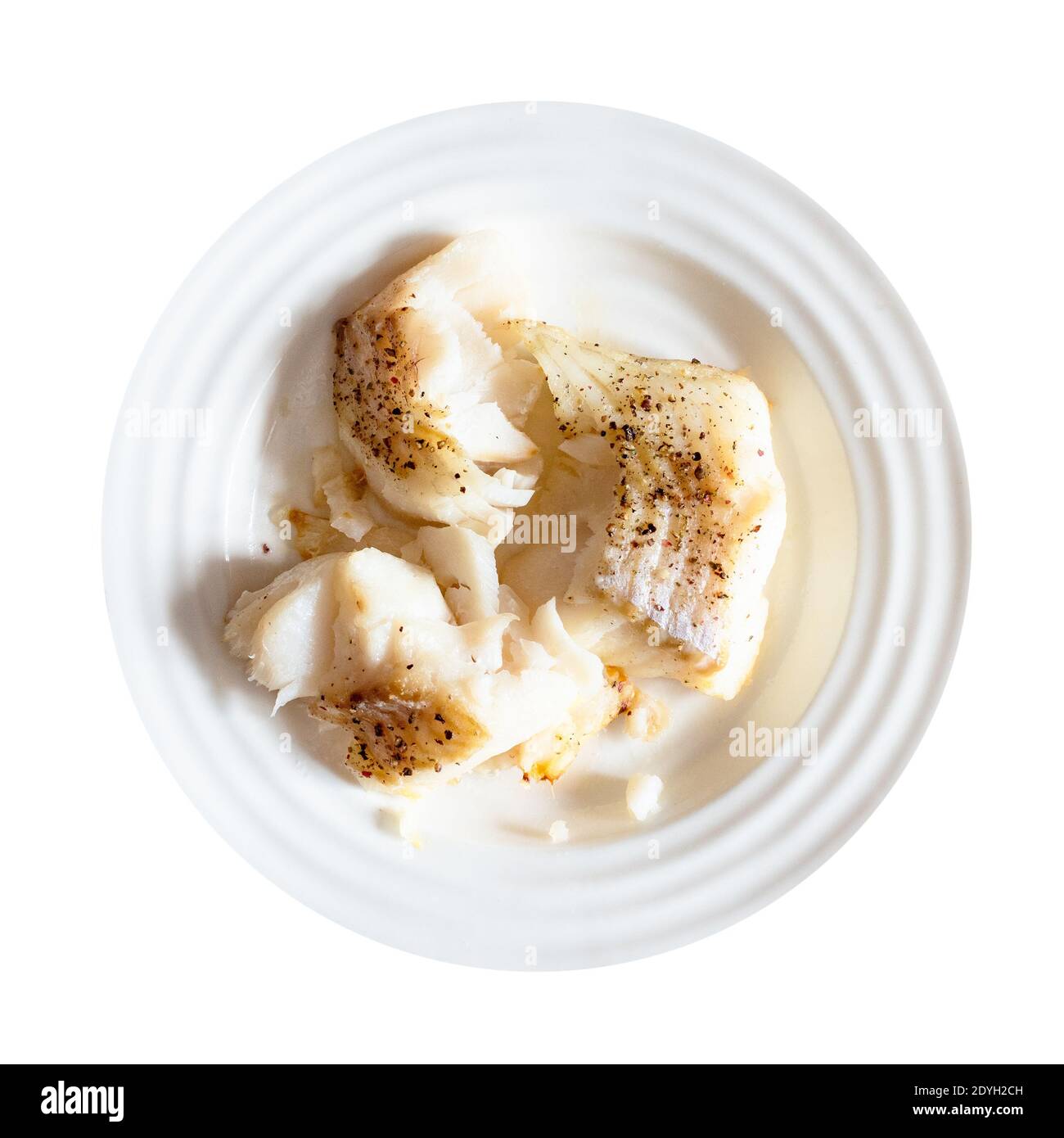 top view of portion of baked and peppered cod fish on white plate cut ...