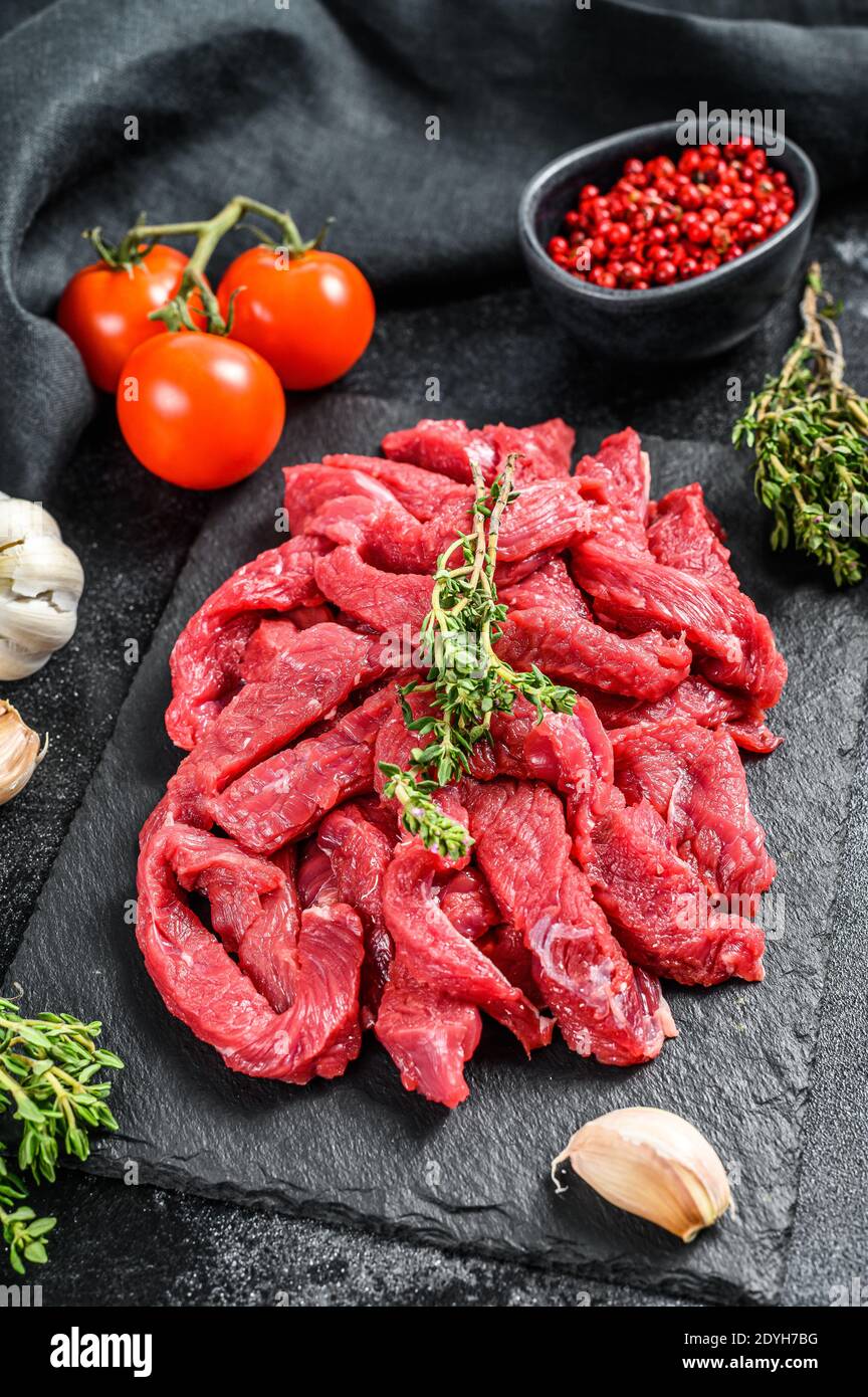 Raw beef Stroganoff meat. Black background. Top view Stock Photo - Alamy