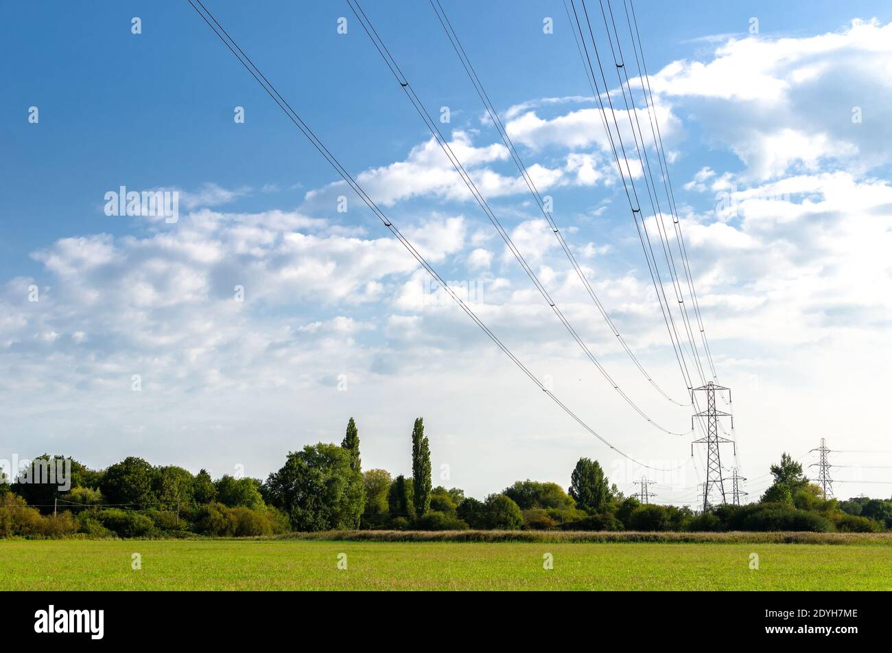 Electricity power lines lines running over a field at Chertsey, England ...