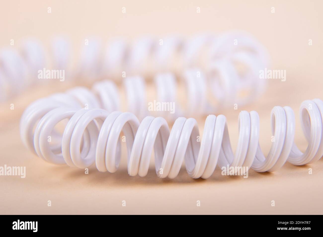 Coiled white wire runs through the picture, green background runs ...