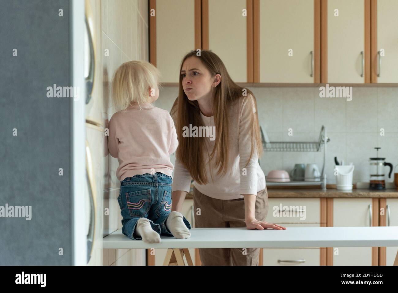 Mom is angry at little child standing in the kitchen Stock Photo - Alamy