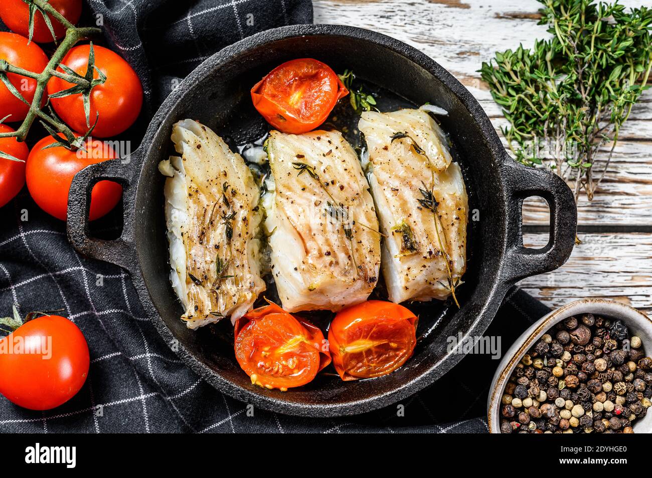 Fried cod fish fillet with spice in a cast iron pan. White background ...