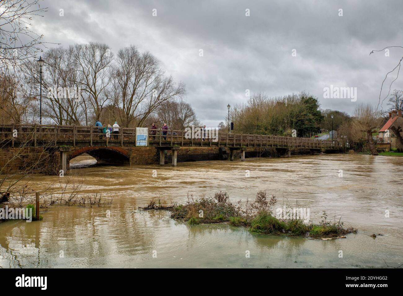 Historic bridge over the river with views of fields flooded with water ...