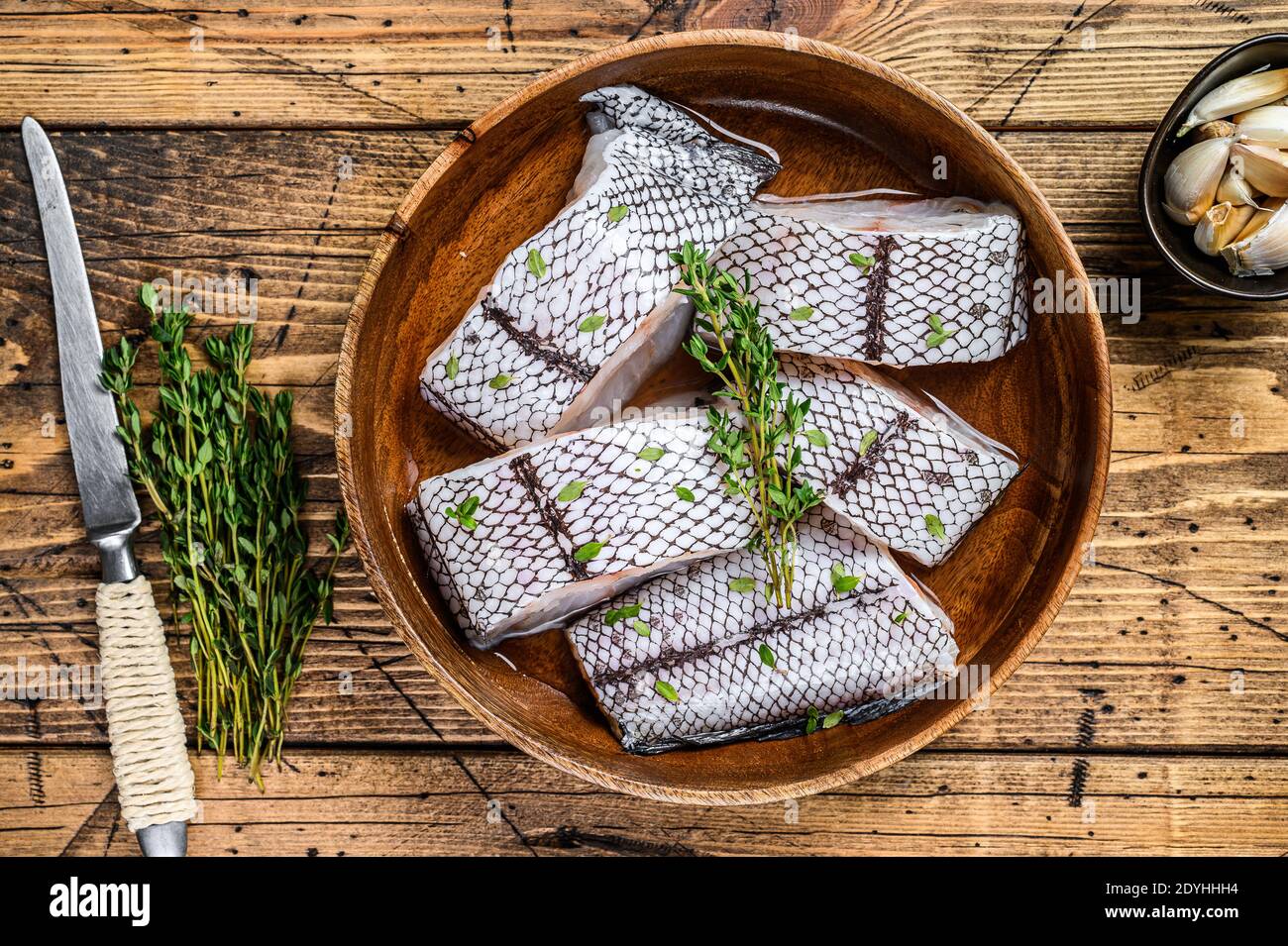 Cut Raw grenadier macrurus white fish without head in a wooden plate ...
