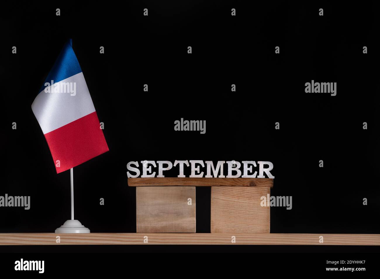 Wooden calendar of September with French flag on black background ...