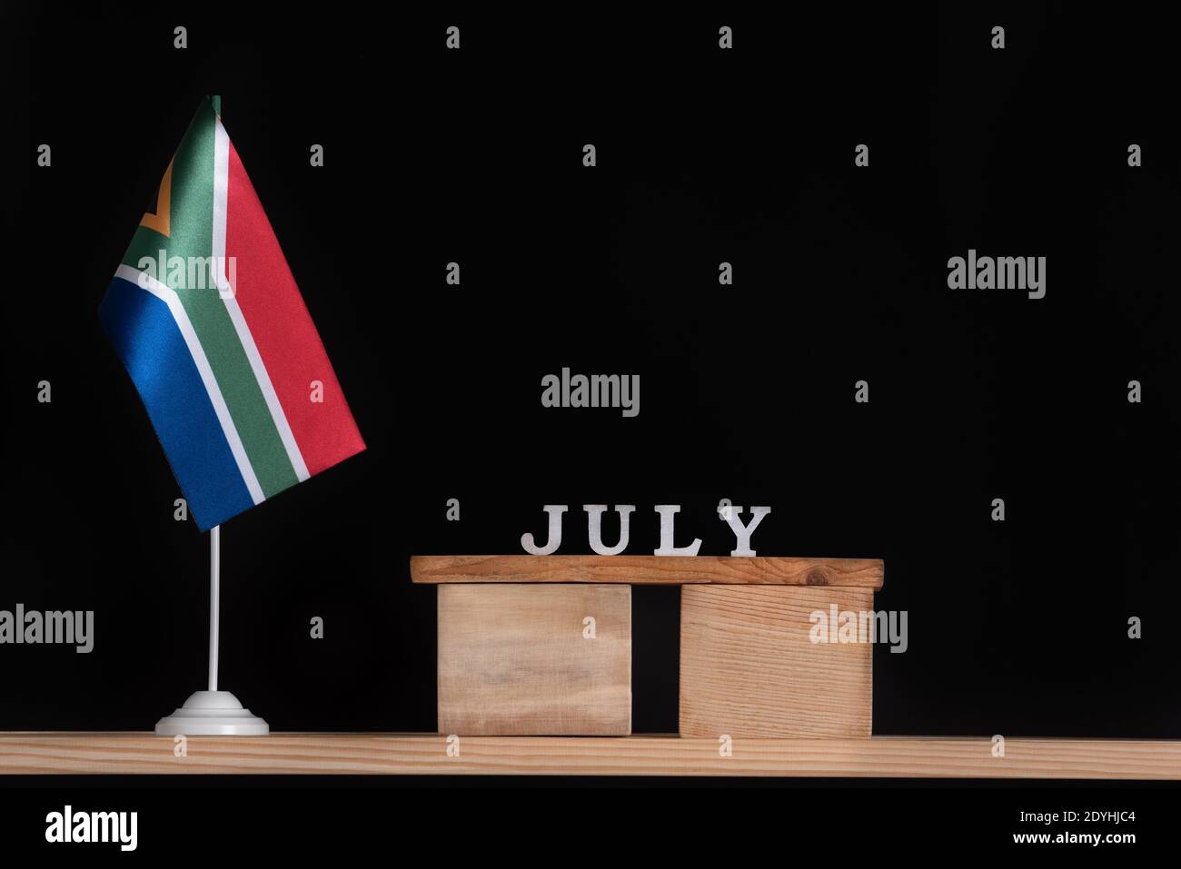 Wooden calendar of July with RSA flag on black background. Dates of ...