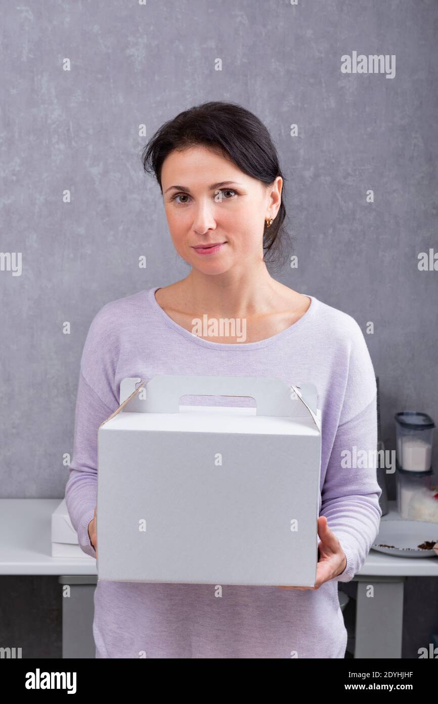 Woman is holding white cardboard box. Vertical frame Stock Photo - Alamy
