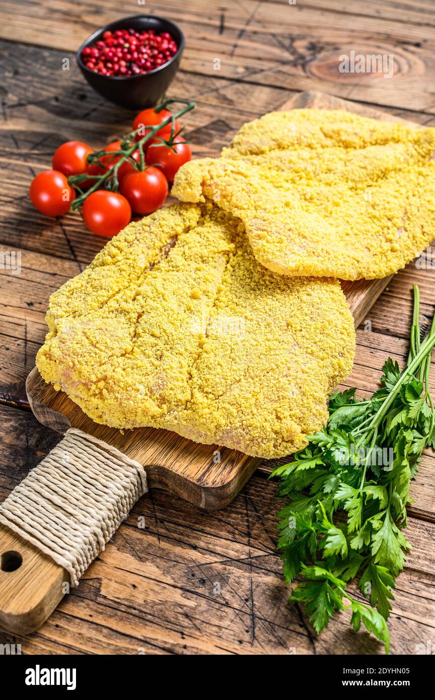 Italian raw Milanese schnitzel. Wooden background. Top view Stock Photo ...