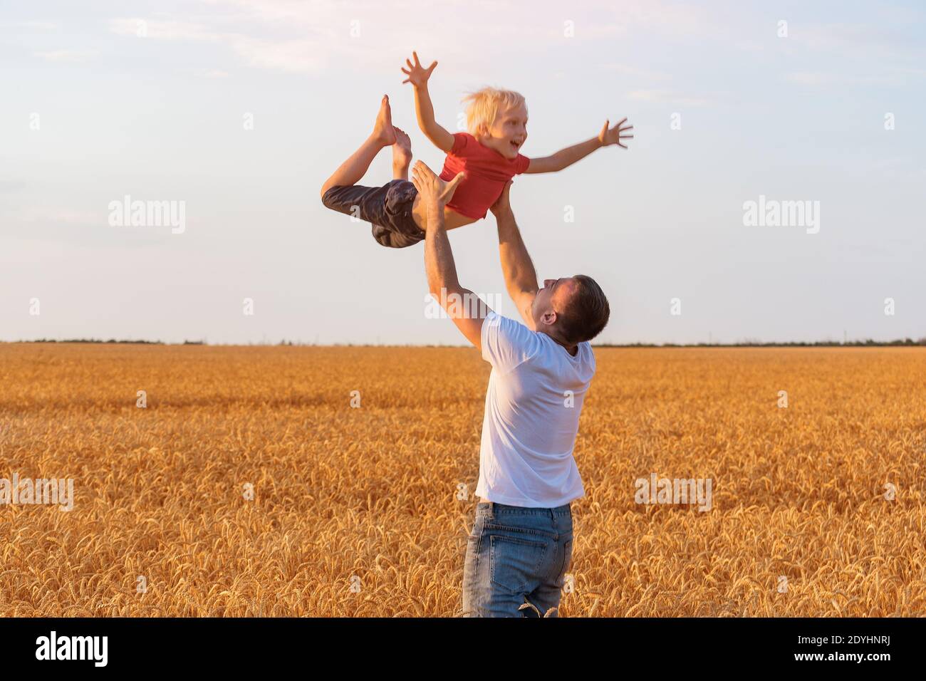 child is flying in fathers arms. Dad tosses son into the air. Father ...