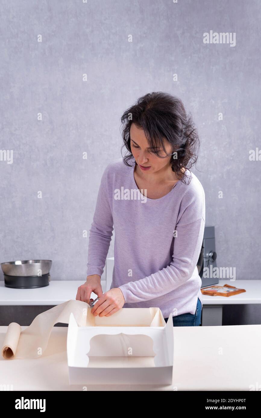 Process of wrapping presentation in gift box. Young woman packing gift ...