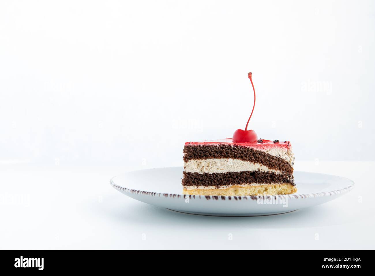 Chocolate and vanilla cake cut into pieces. There is cherry on top ...