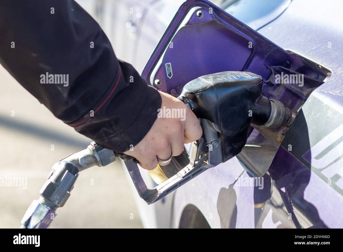 Man holding gas pump filling up car with gas close up . High quality ...