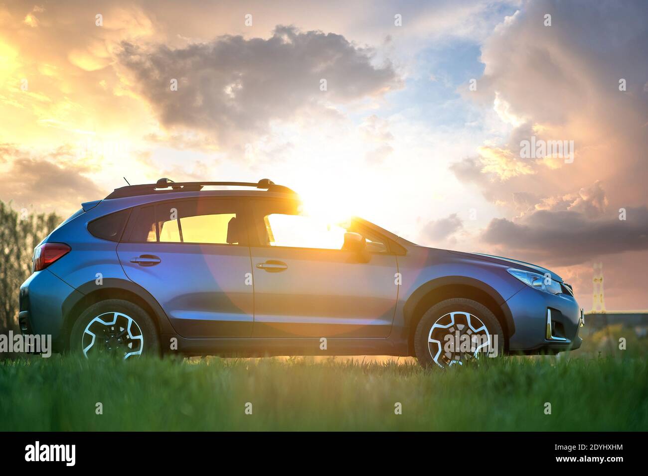 Landscape with blue off road car on green grass at sunset. Traveling by ...