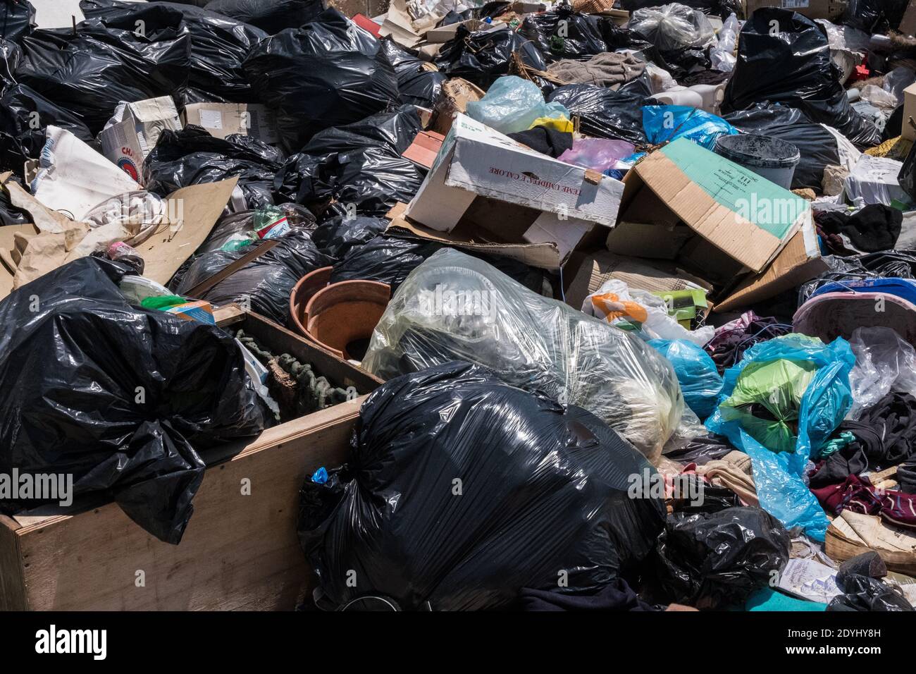 detail of trash or waste with plastic bags and bottles under the sun ...
