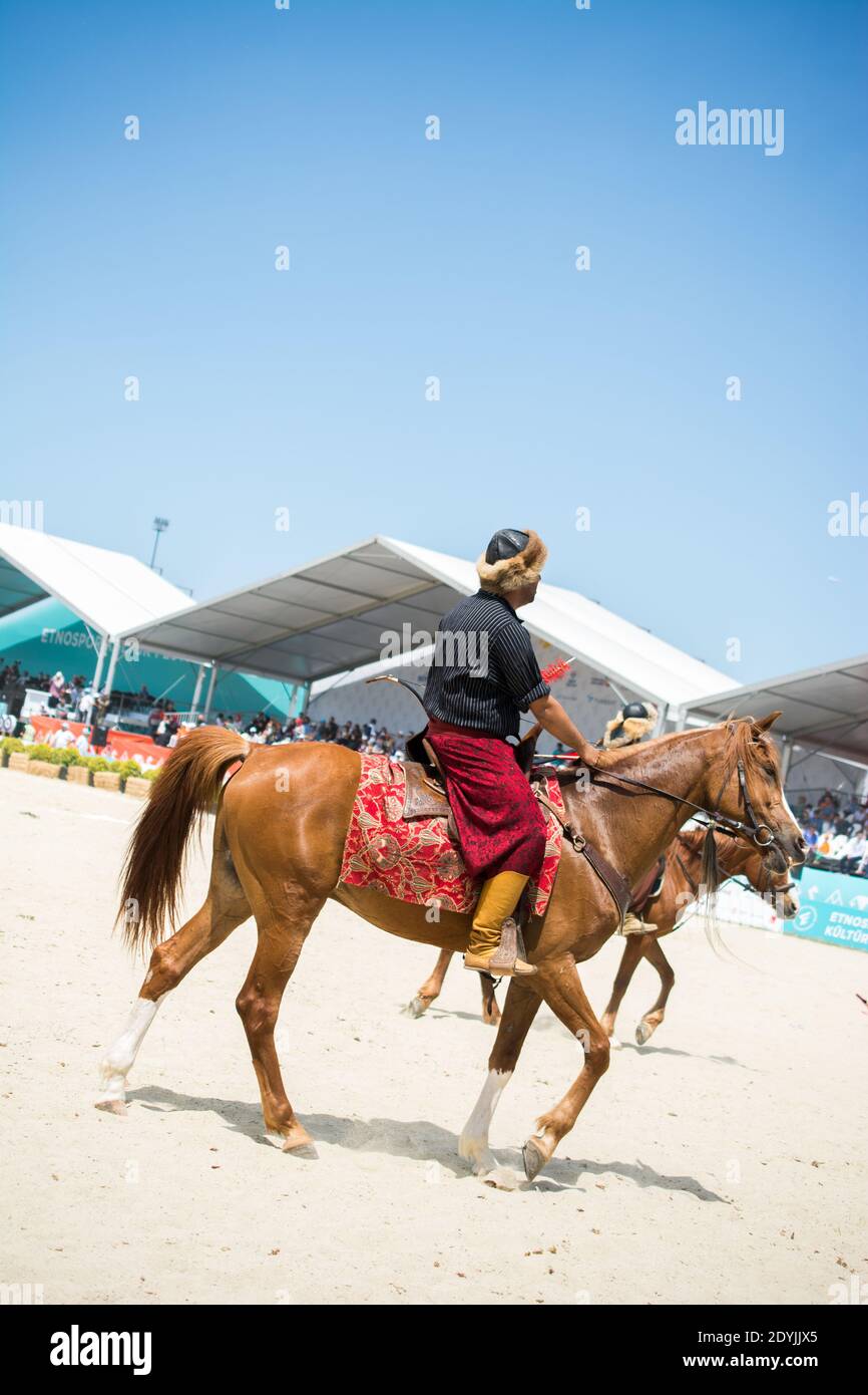 A vertical shot of a male in traditional clothes riding on the back of ...
