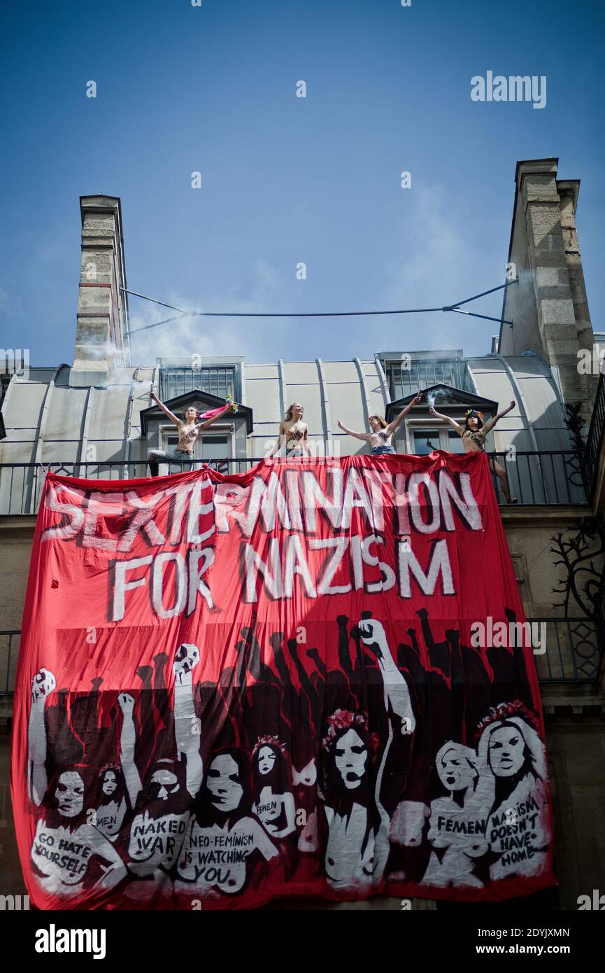 Members of women's rights movement Femen display a banner reading ...