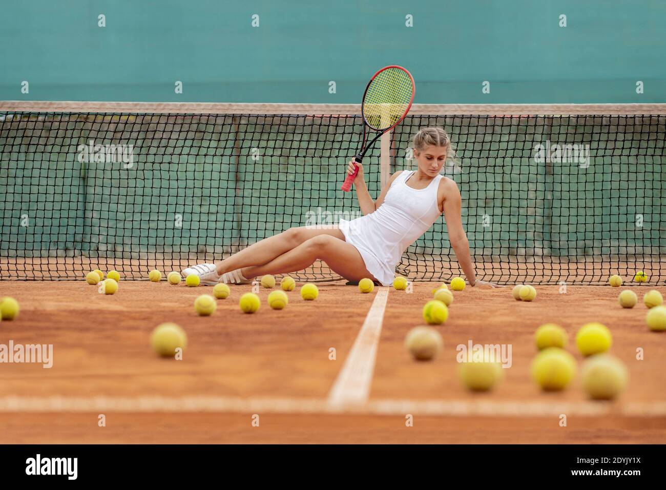 professional tennis player woman with racket and ball near net on court ...